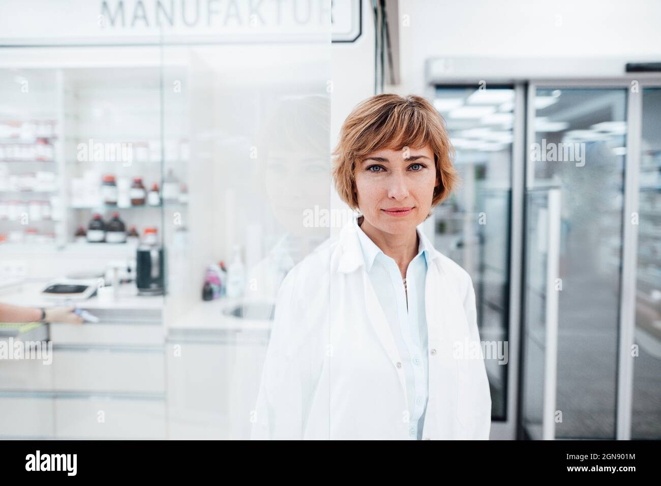 Female professional wearing lab coat standing at medical store Stock ...