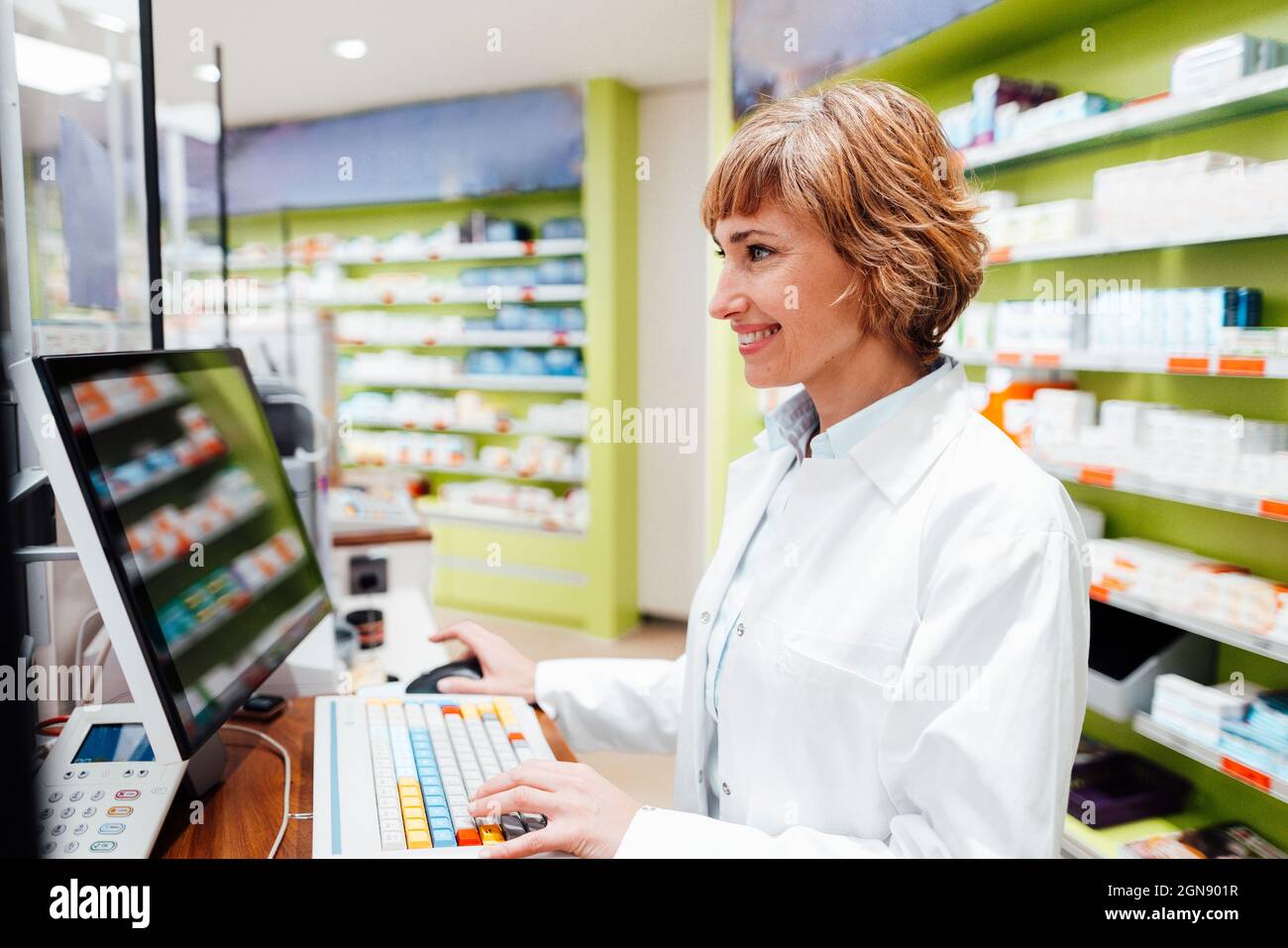 Happy pharmacist using computer hi-res stock photography and images - Alamy