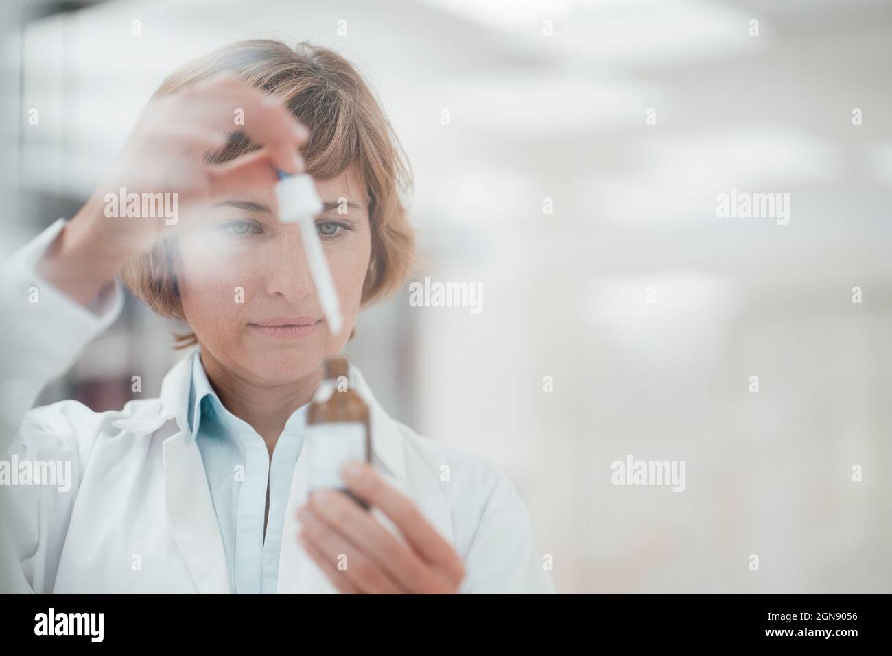 Female pharmacist with pipette examining at laboratory Stock Photo - Alamy