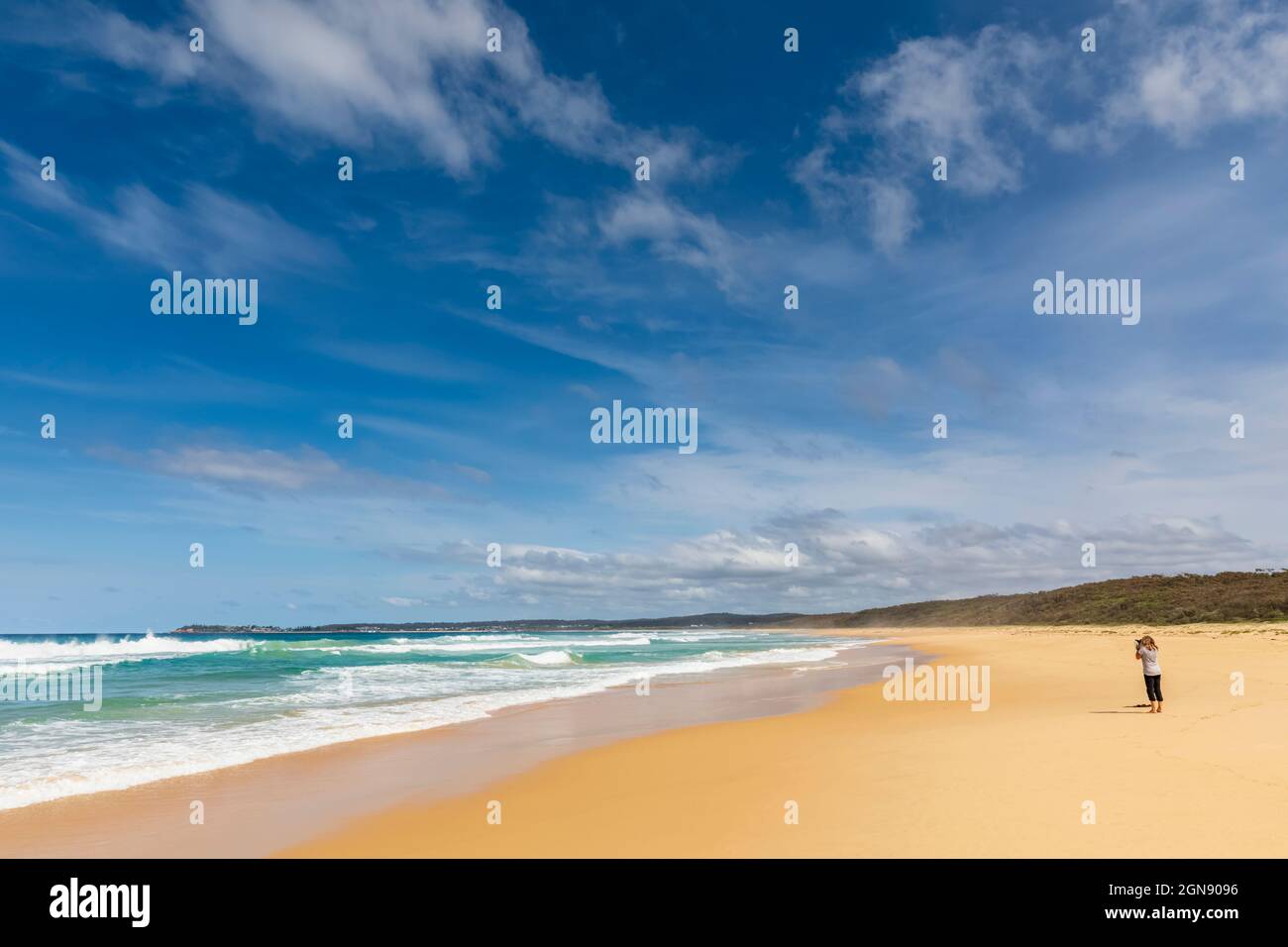 Lone tourist taking photos at Haywards Beach Stock Photo - Alamy