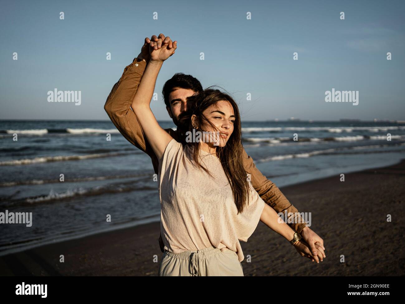Young couple holding hands while dancing on beach Stock Photo - Alamy
