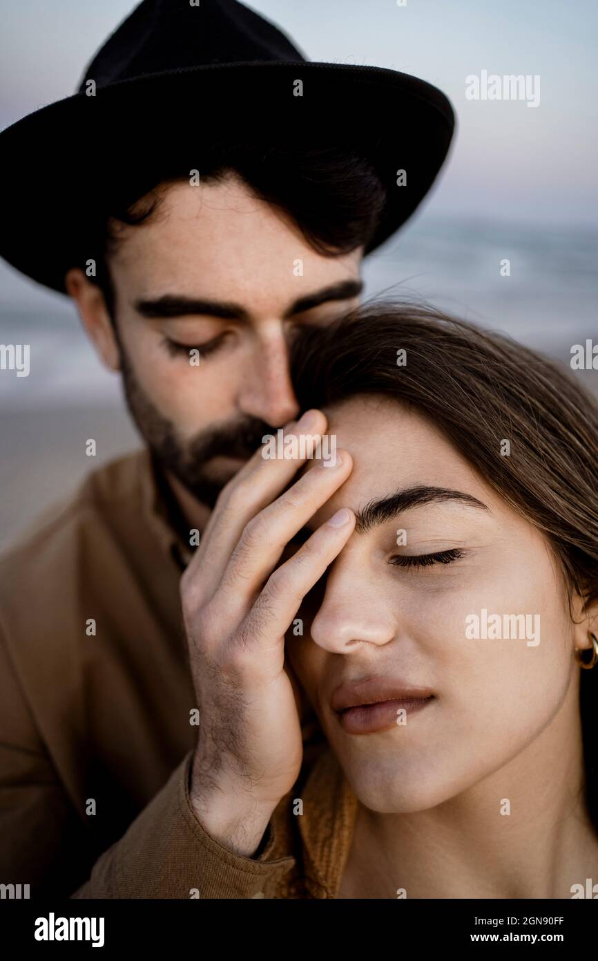 Boyfriend touching girlfriend face Stock Photo - Alamy