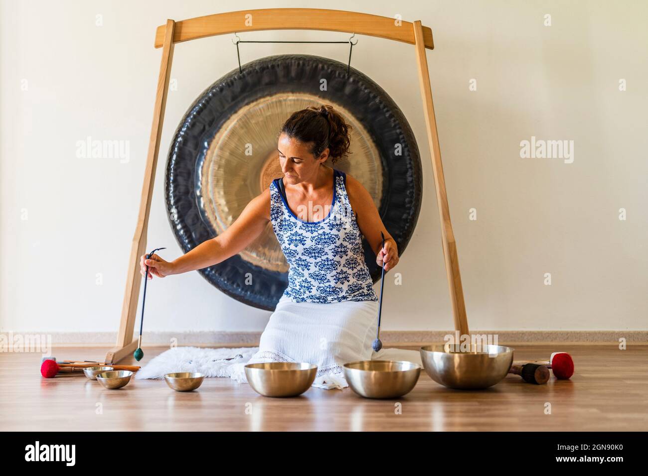 Female sound therapist playing percussion Instrument in studio Stock ...
