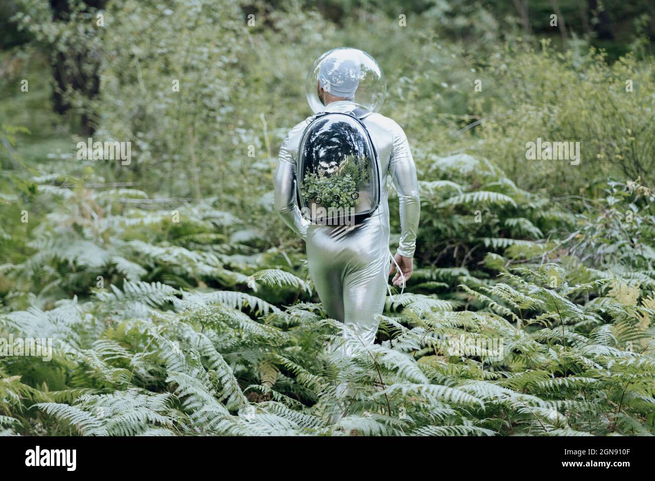 Male environmentalist with protective suit and glass backpack walking ...
