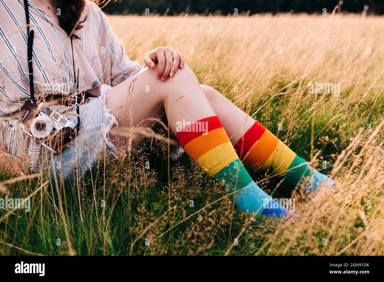 Woman with camera and rainbow socks sitting on grass Stock Photo - Alamy