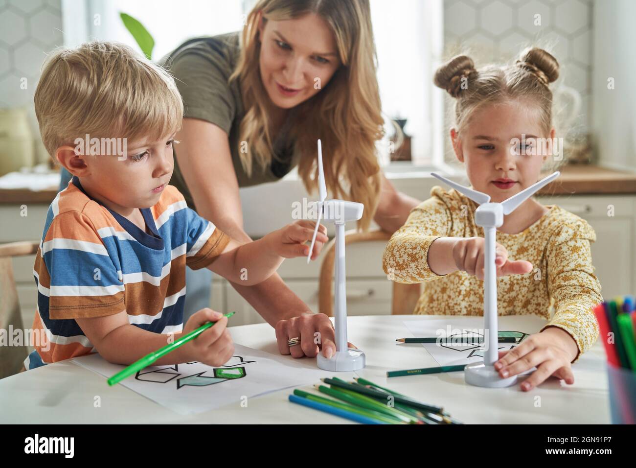 Mother teaching about wind turbine model to children at home Stock ...