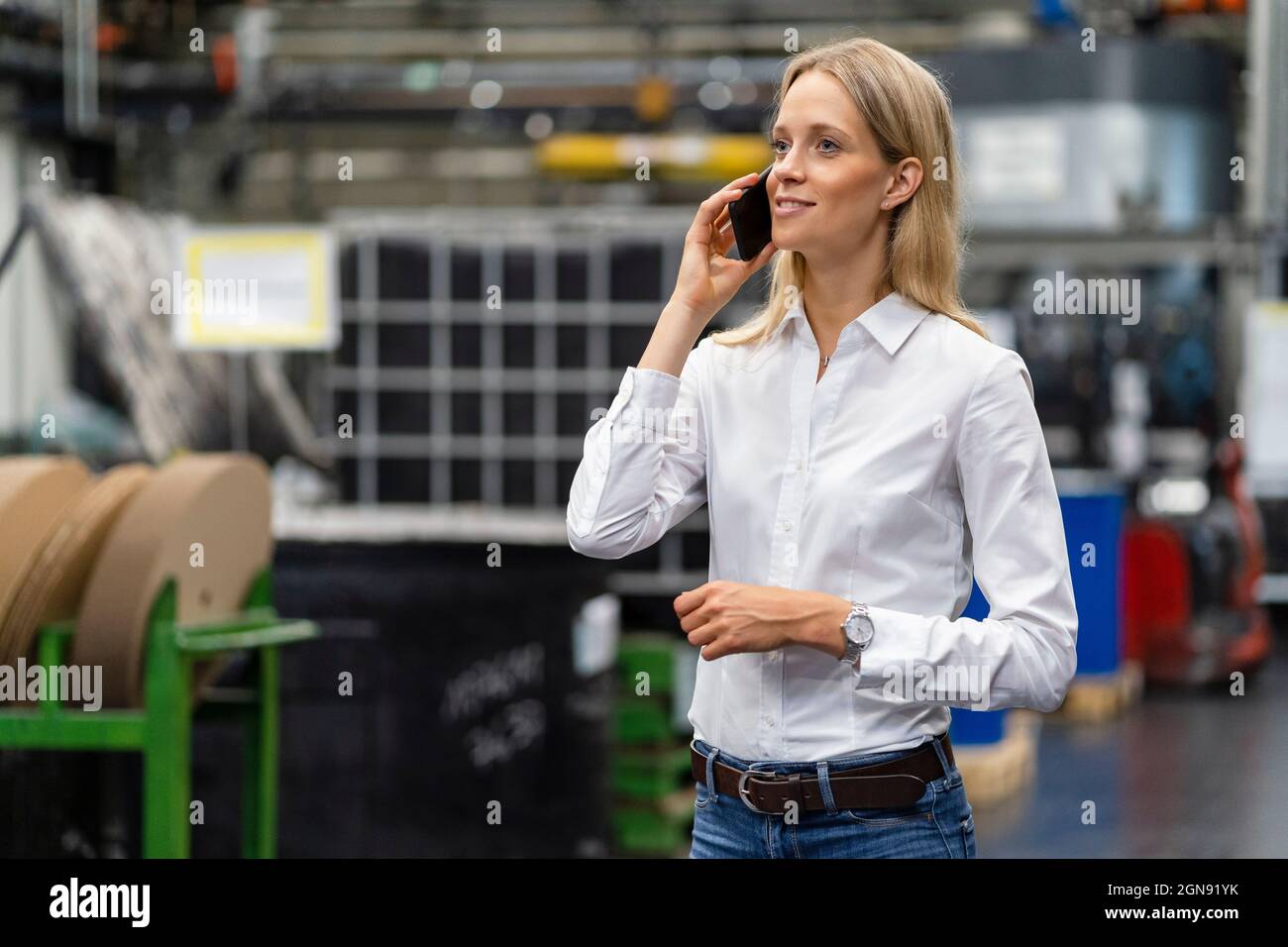 Female business professional talking on mobile phone at industry Stock ...
