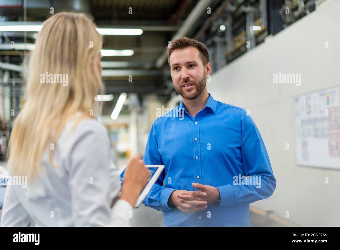 Female professional sharing expertise with colleague at industry Stock ...