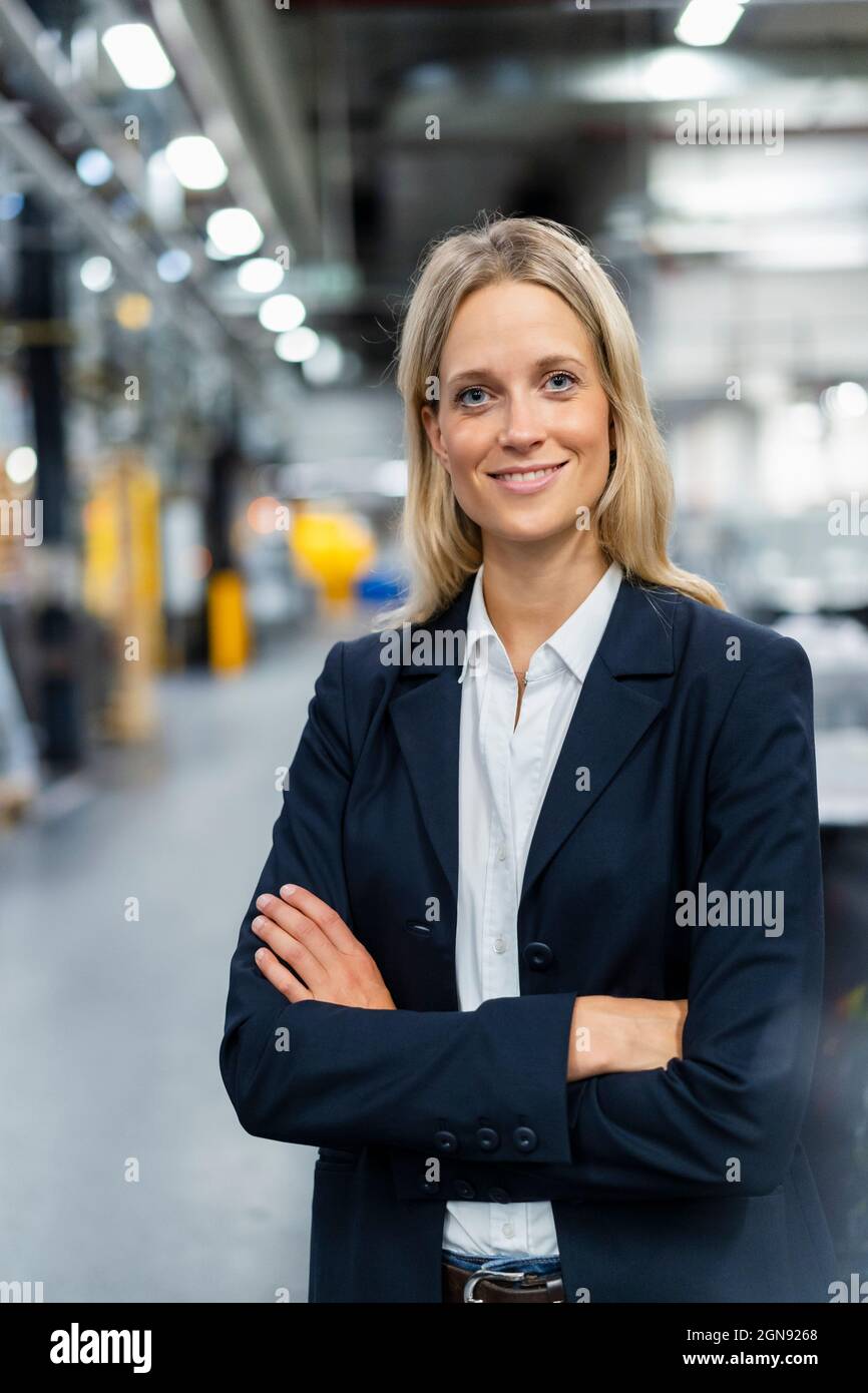 Female manger standing with arms crossed at industry Stock Photo - Alamy
