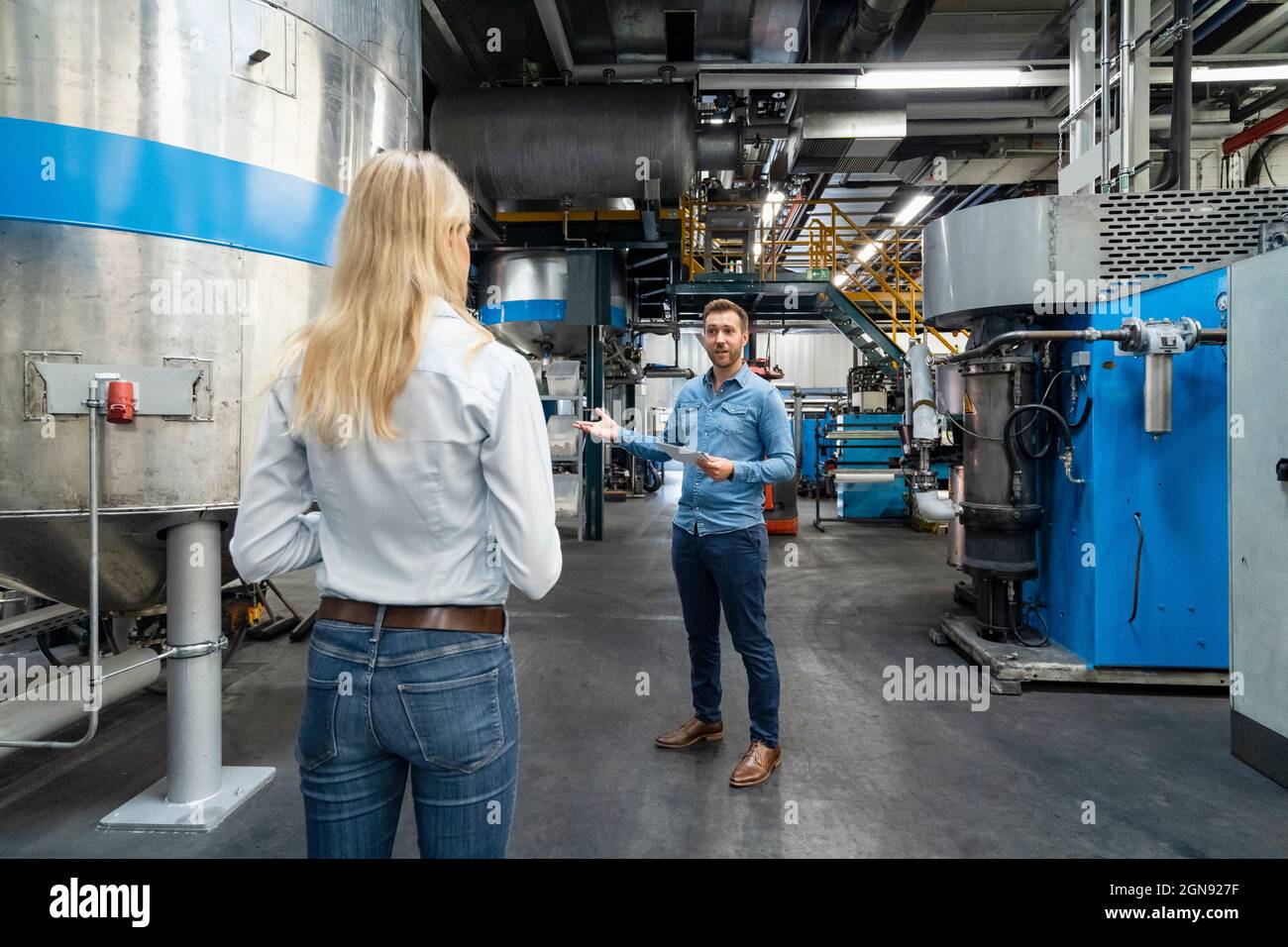 Businessman pointing at manufacturing machine while working with ...