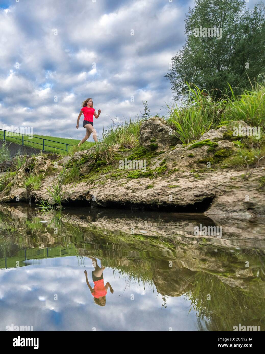 Young woman jogging along bank of Rems river Stock Photo - Alamy