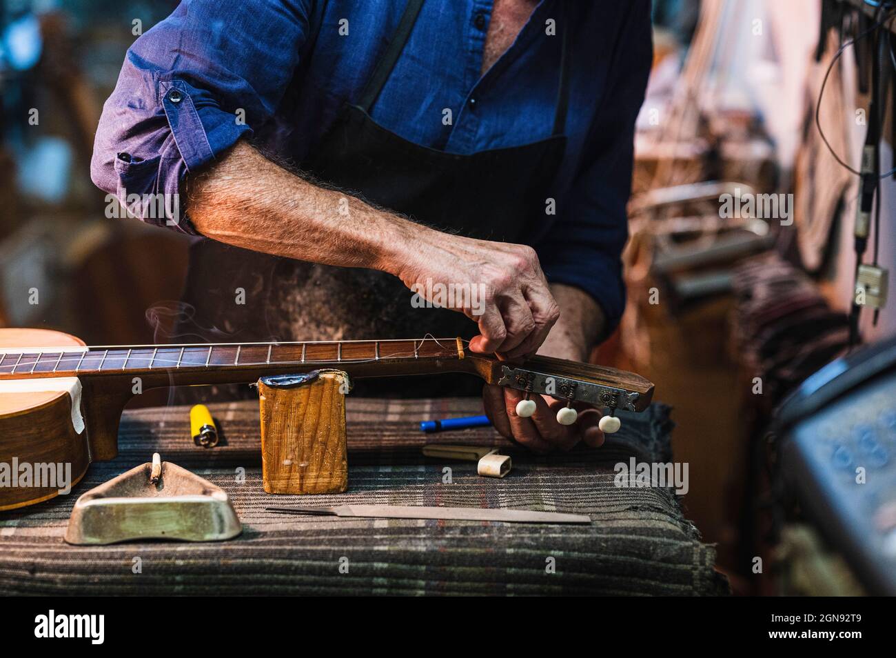 Luthier repairing guitar in workshop Stock Photo - Alamy