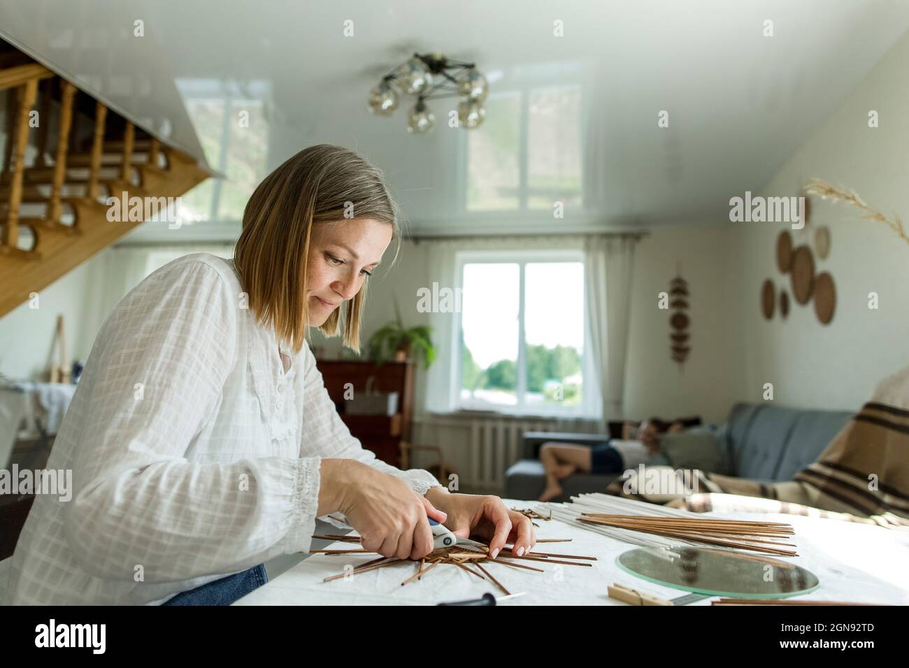 Woman making basket from paper vine at home Stock Photo - Alamy
