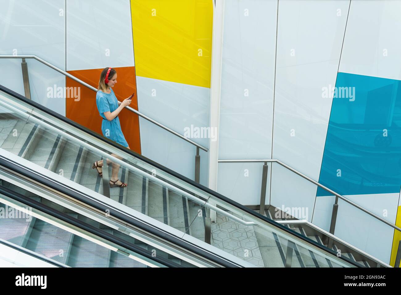 Businesswoman using mobile phone while moving down on steps Stock Photo ...