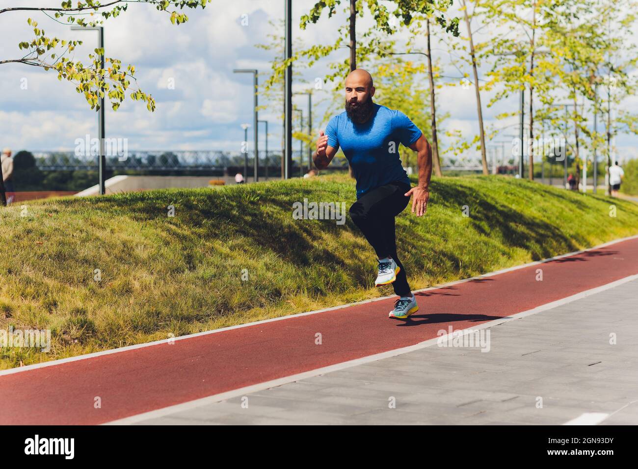 Young athlete running fast outdoors. Wearing sport cloth, doing wide ...