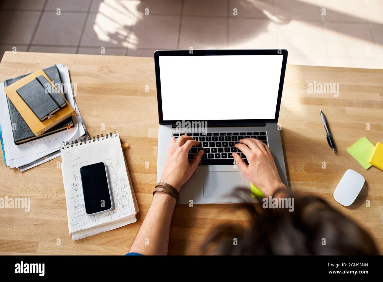 Male professional typing on laptop while working at desk in office ...