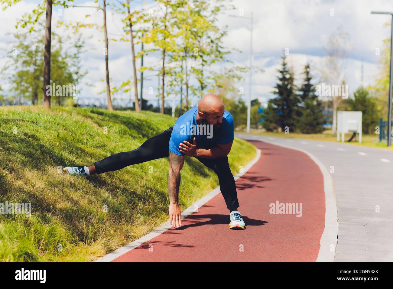 Young athlete running fast outdoors. Wearing sport cloth, doing wide ...