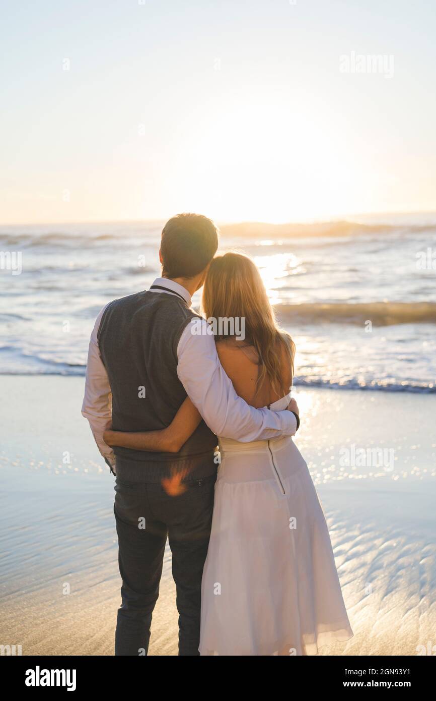 Newlywed couple with arm around at beach Stock Photo - Alamy
