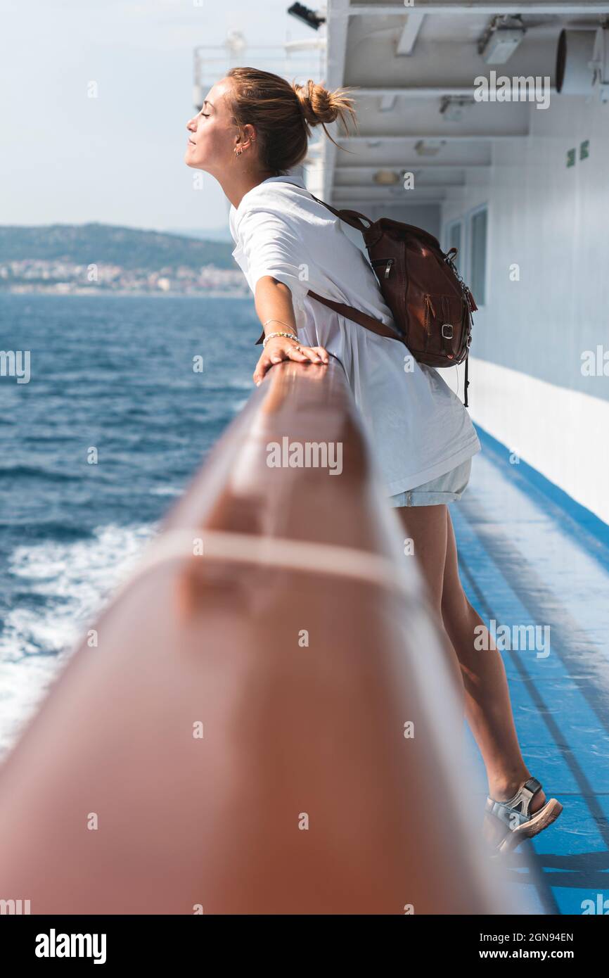 Young woman leaning on railing at boat during vacation Stock Photo - Alamy