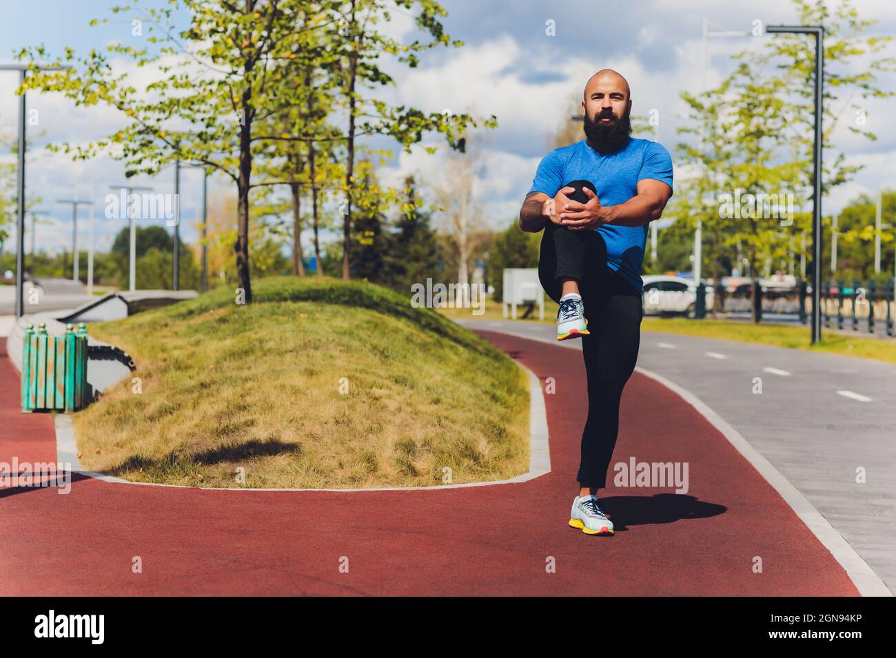 Young athlete running fast outdoors. Wearing sport cloth, doing wide ...