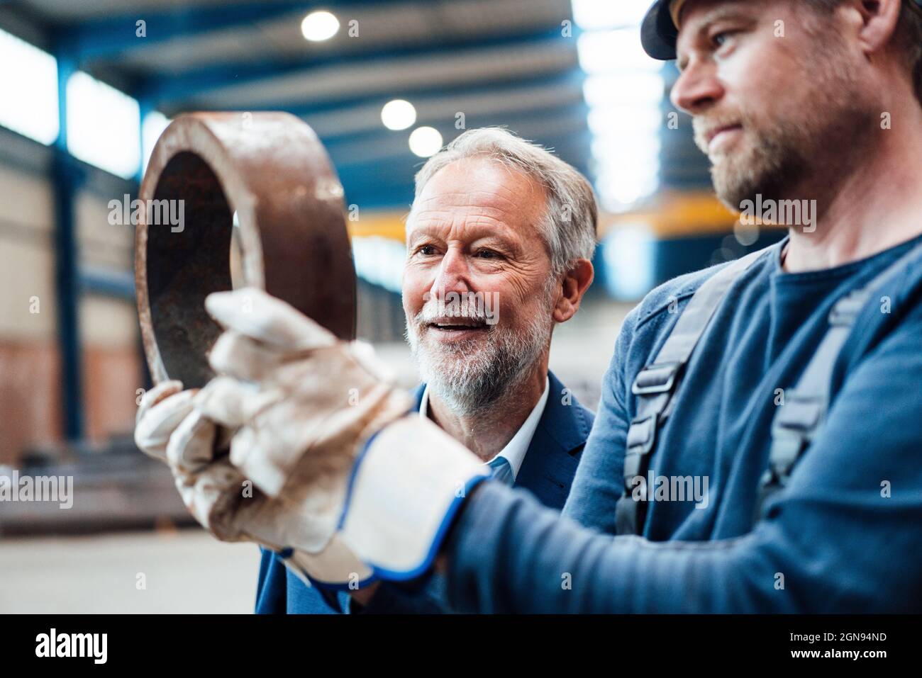 Male managing director discussing with warehouse worker in industry ...