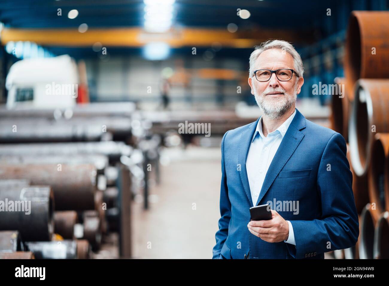 Male managing director sitting on armchair in factory Stock Photo - Alamy