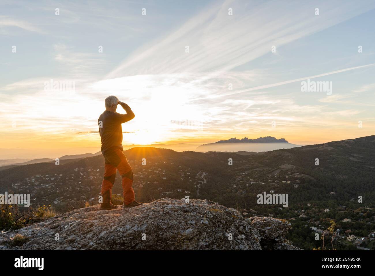 Senior man looking at mountains during sunset Stock Photo - Alamy