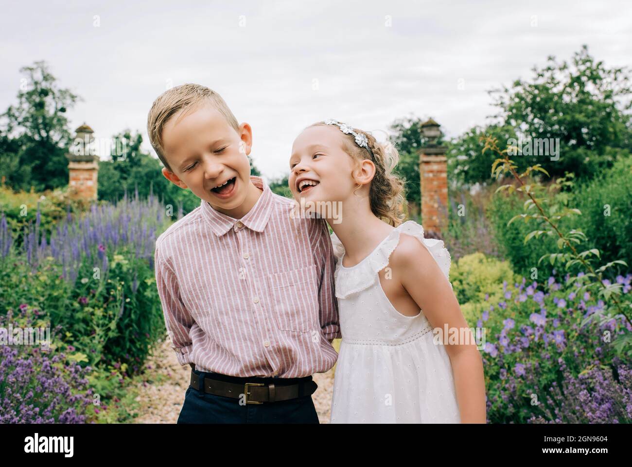 Boy and girl laughing happily in a beautiful flower field Stock Photo ...