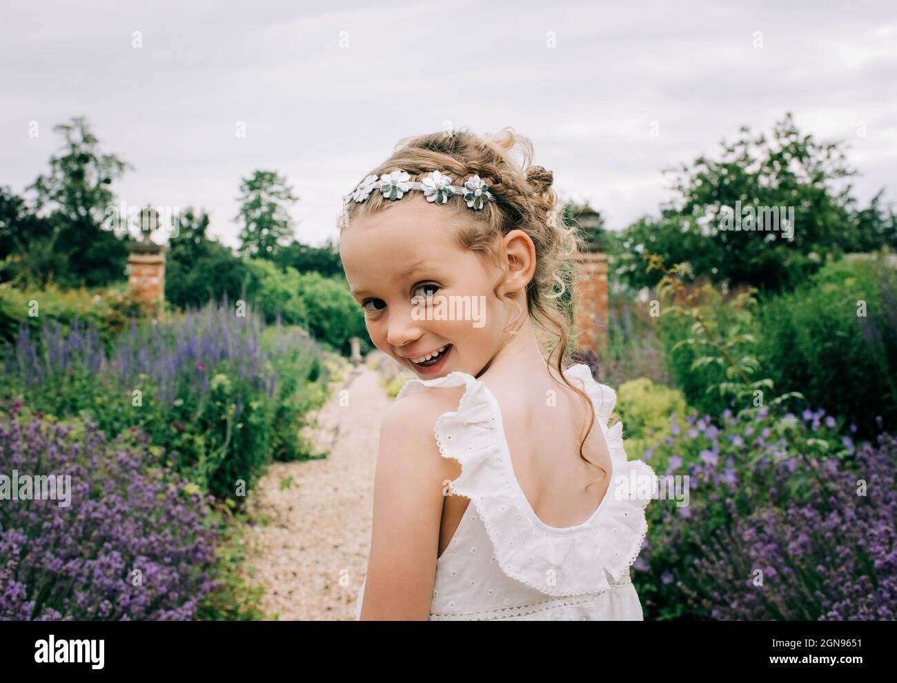 young flower girl smiling at a wedding in a beautiful field of flowers ...