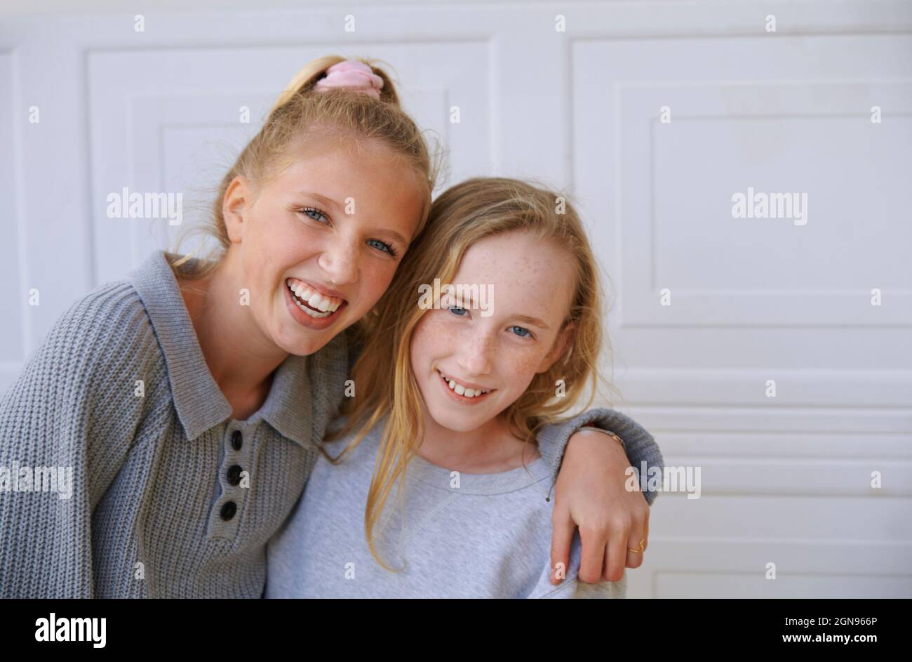Happy girls embracing in front of door Stock Photo - Alamy