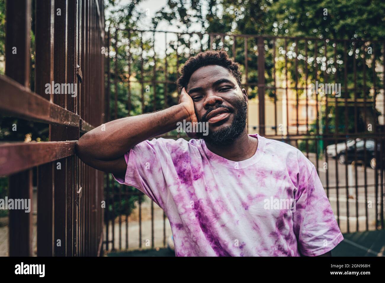 Smiling young man leaning on railing Stock Photo - Alamy