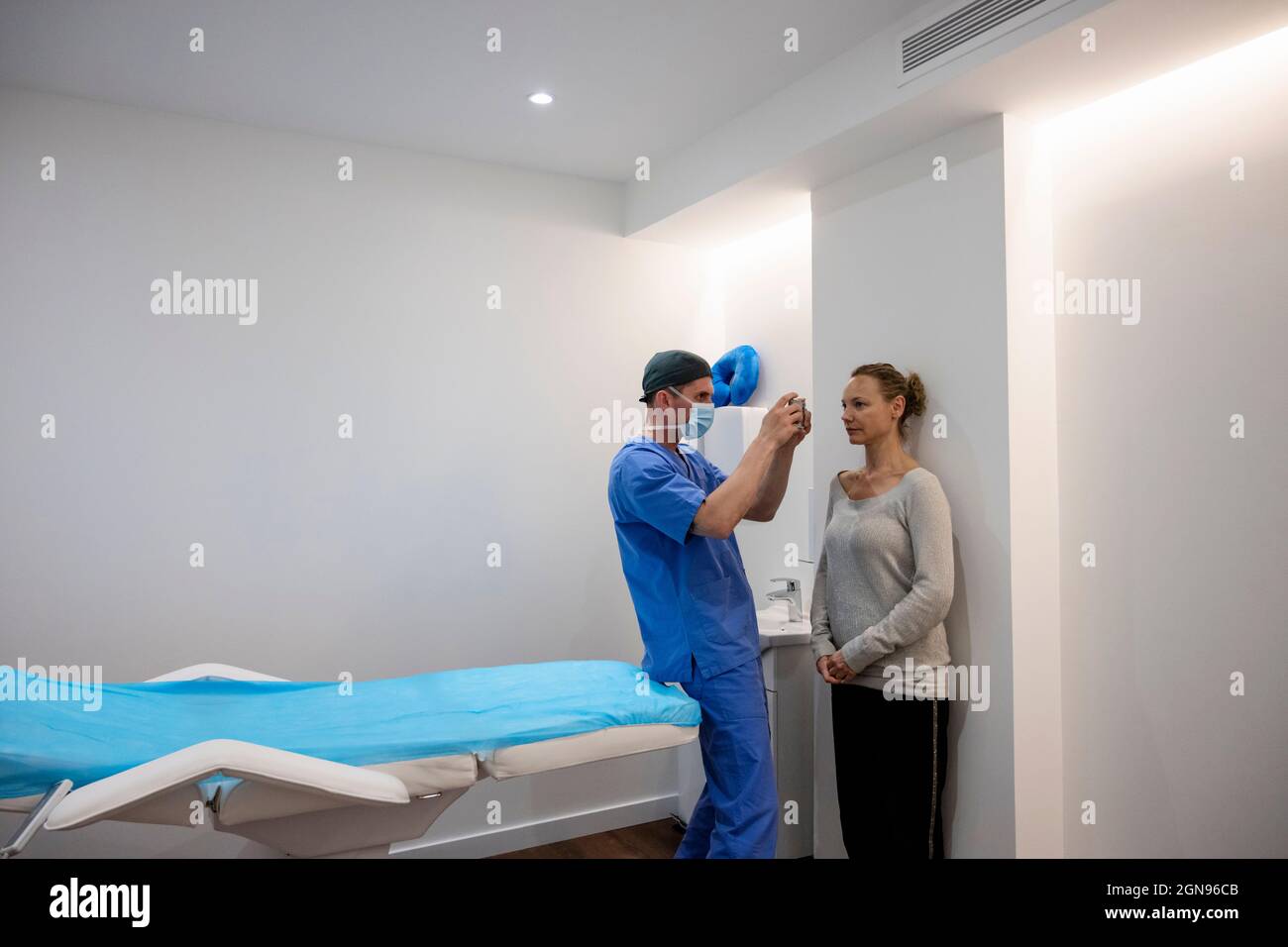Aesthetic surgeon taking photograph of patient before operation Stock ...