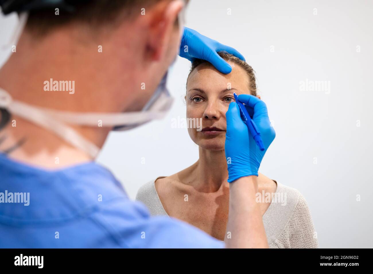 Surgeon drawing line on girl eye with marker preparing for procedure ...