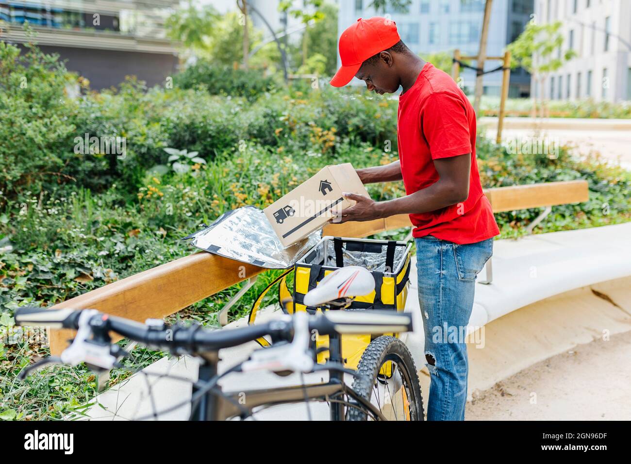 Delivery man examining package at bench Stock Photo - Alamy