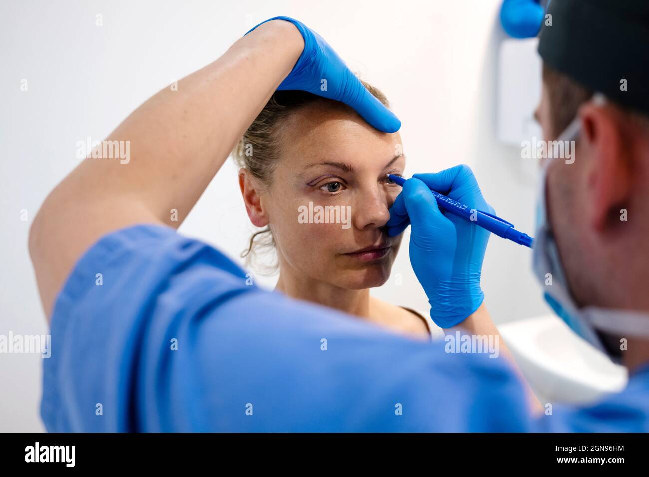 Surgeon drawing line on girl eye with marker preparing for procedure ...