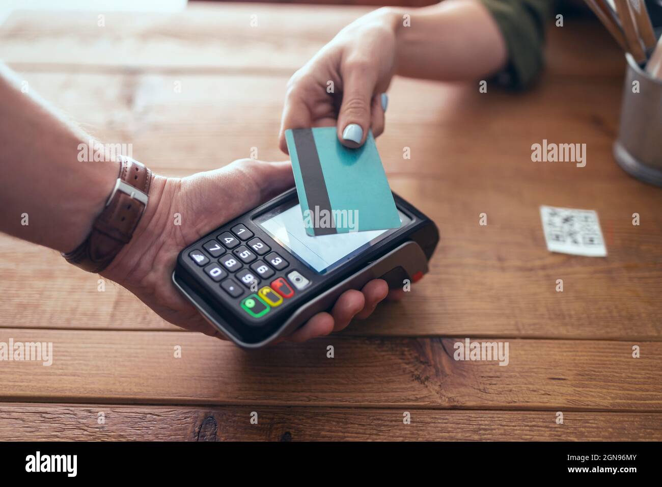 Female customer making contactless payment through credit card in ...