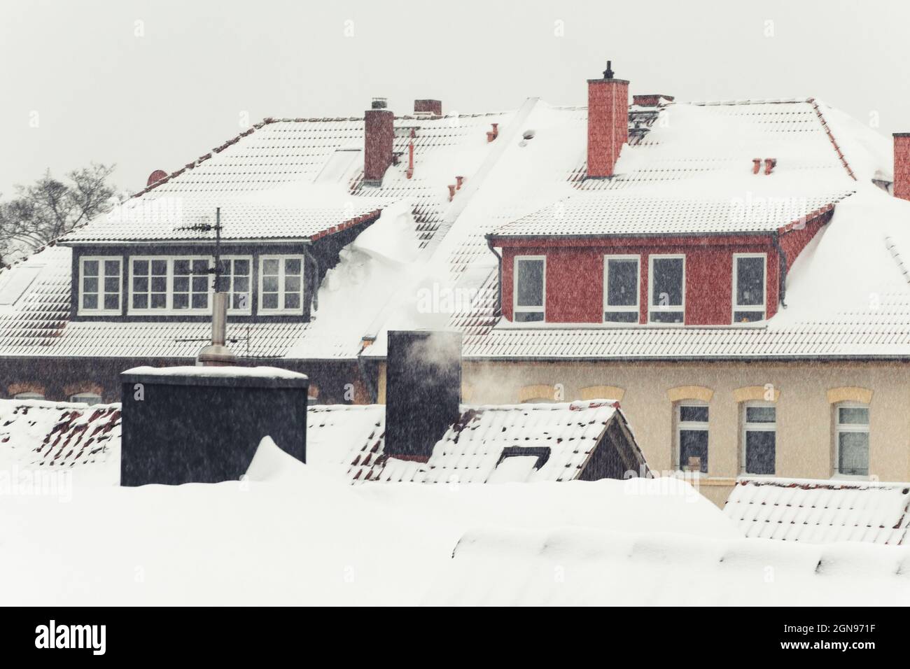 Snow covered rooftops in the city and white sky. Symbol for christmas ...