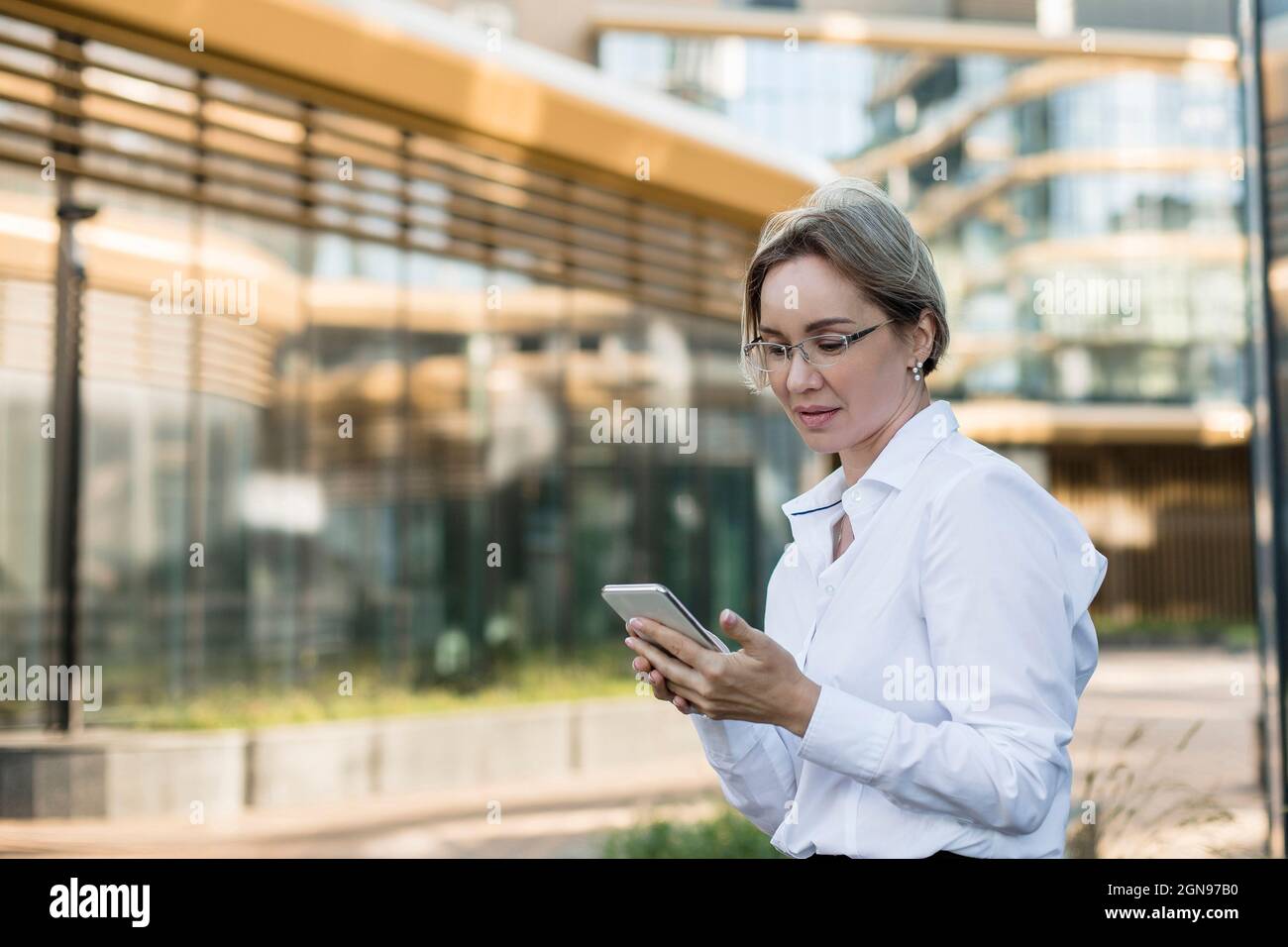 Businesswoman wearing eyeglasses using mobile phone Stock Photo - Alamy