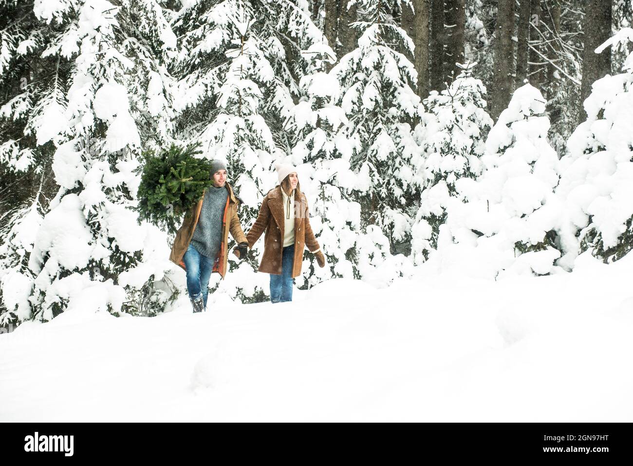Boyfriend and girlfriend walking in forest during winter Stock Photo ...