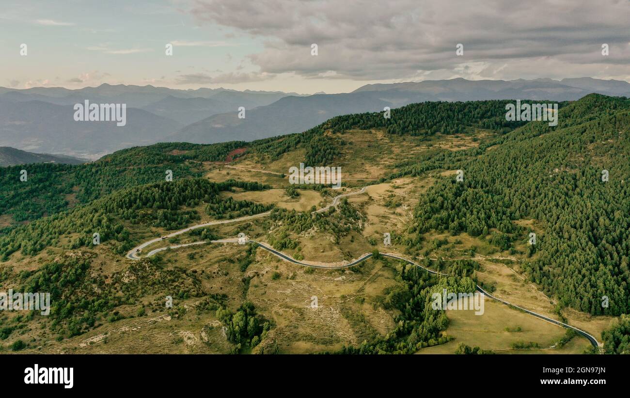 Aerial view of country road stretching through forested landscape of ...