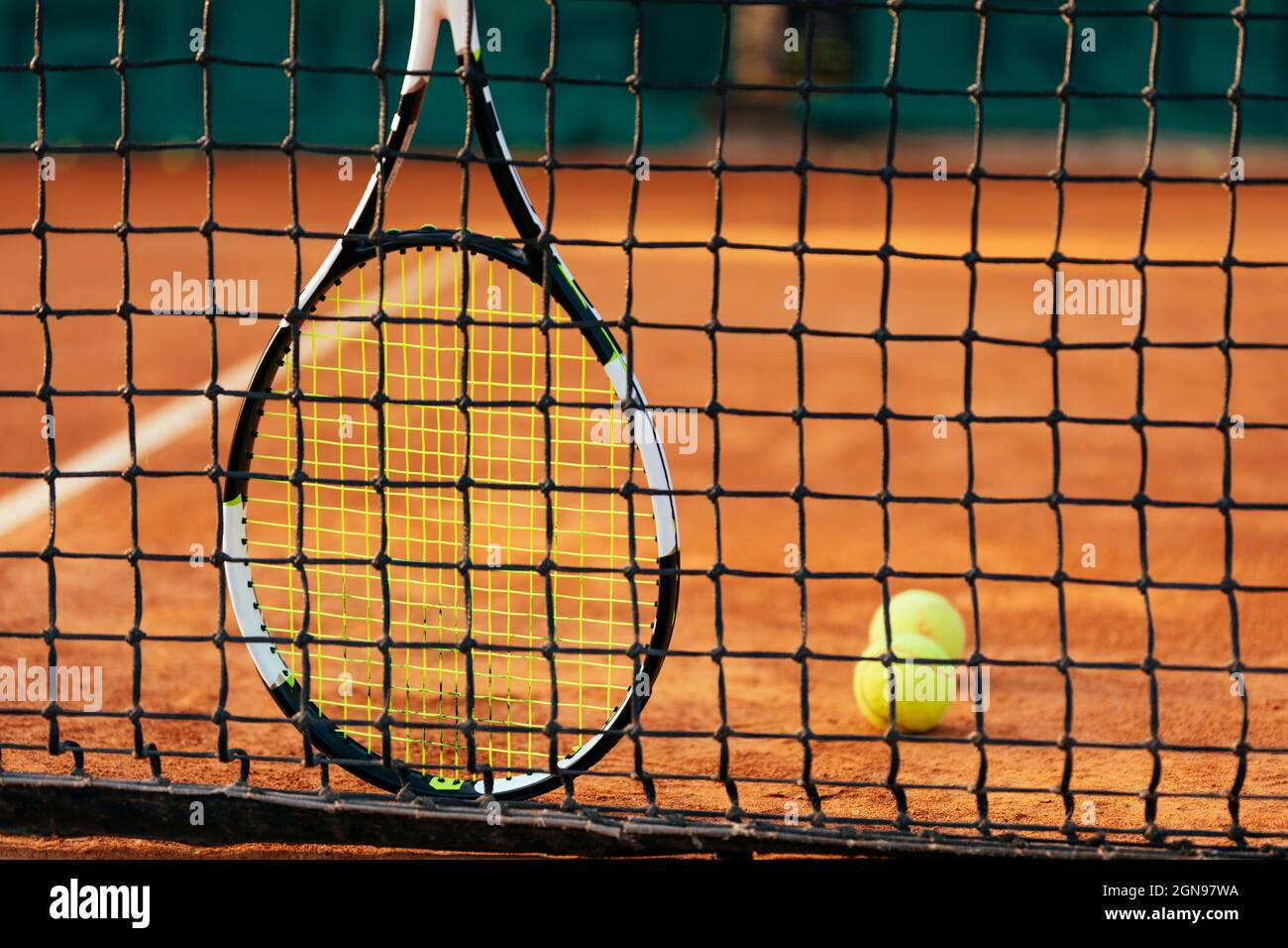 Tennis racket and ball by net at at sports court Stock Photo - Alamy