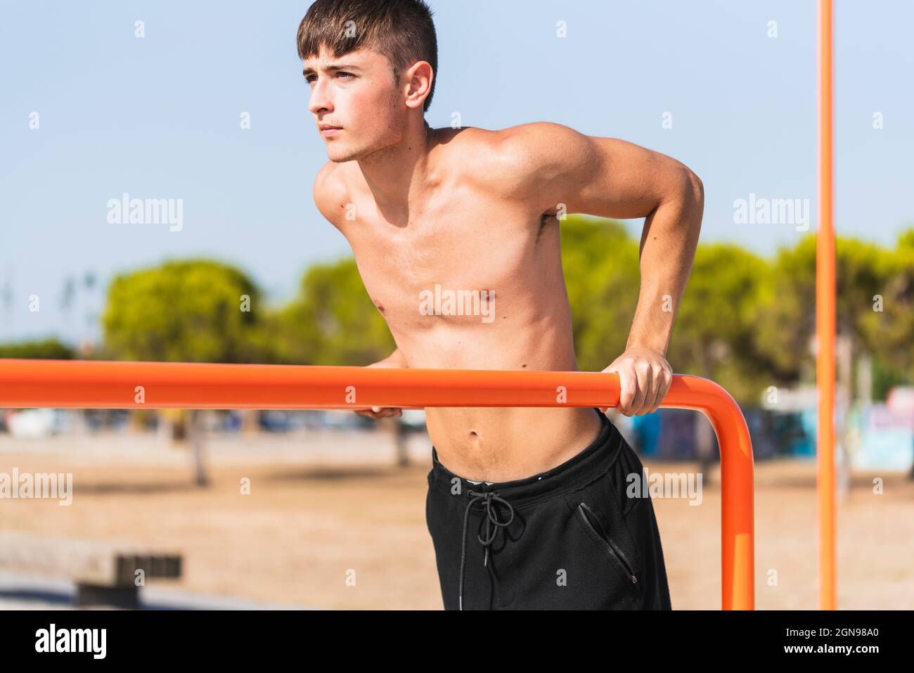 Young man practicing calisthenics on parallel bars Stock Photo - Alamy