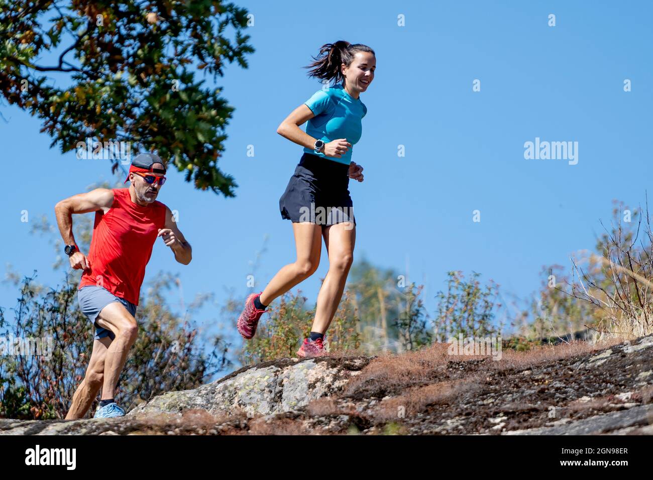 Mature male coach running with female athlete during sunny day Stock ...