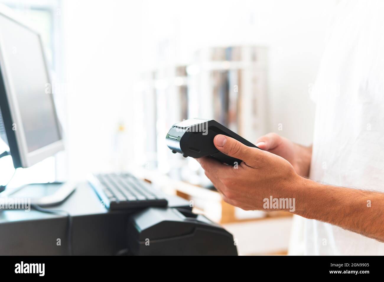 Male store owner using credit card reader at counter Stock Photo - Alamy