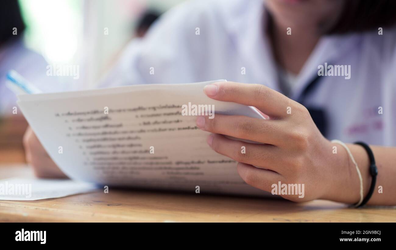 Students writing and reading exam answer sheets exercises in classroom ...