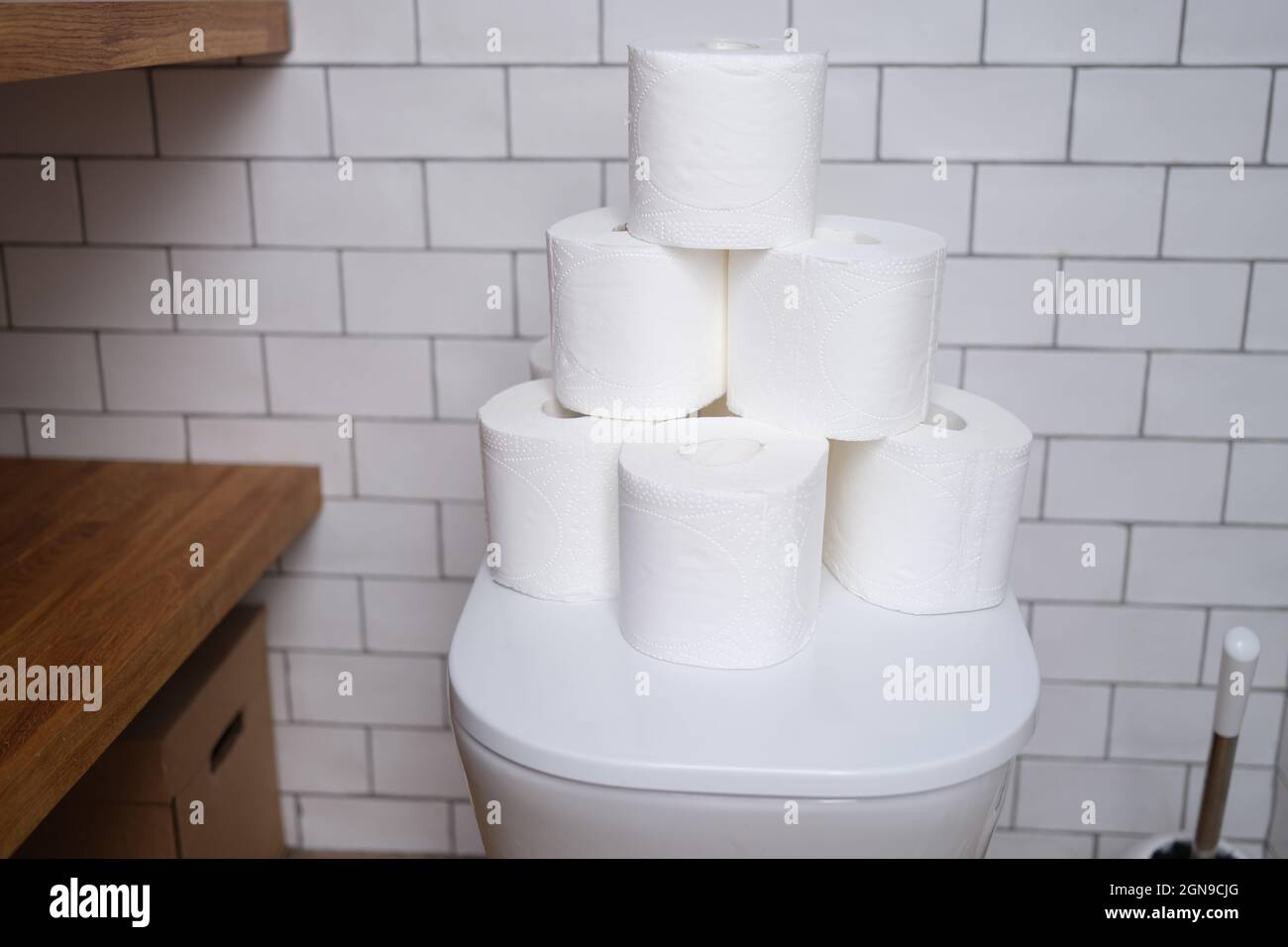 Stack of toilet paper stands on white toilet in bathroom closeup Stock ...