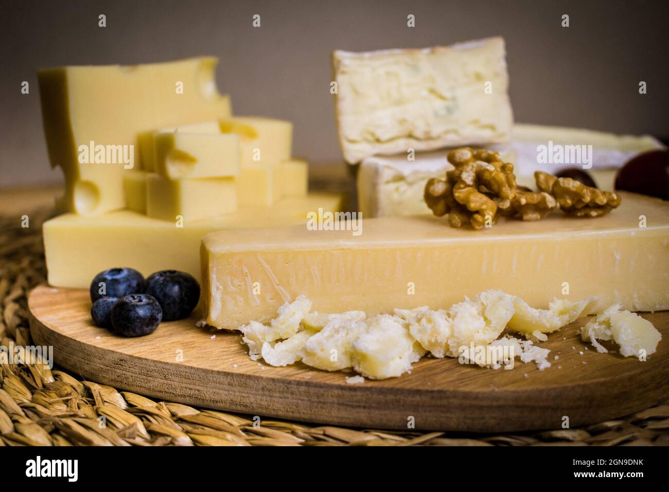 Appetizing display of assorted cheese slices and blocks on a wooden ...