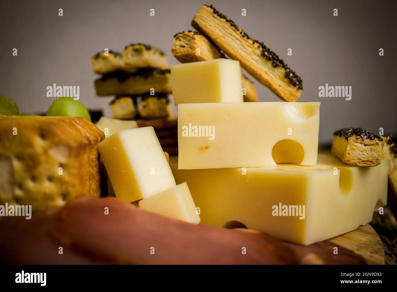 Appetizing display of cheese slices and breadsticks Stock Photo - Alamy