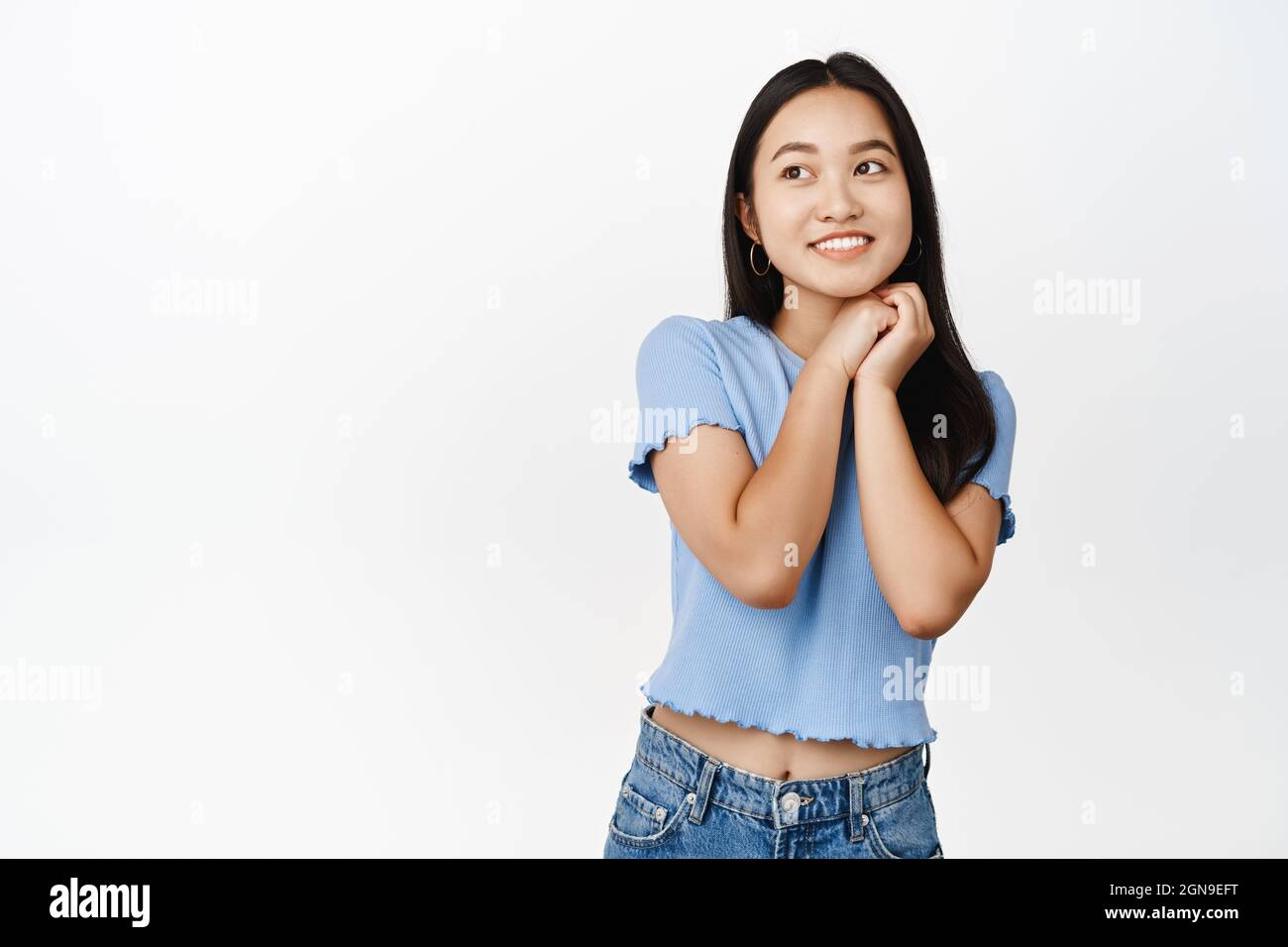 Dreamy brunette asian girl thinking, yearning for something, smiling ...