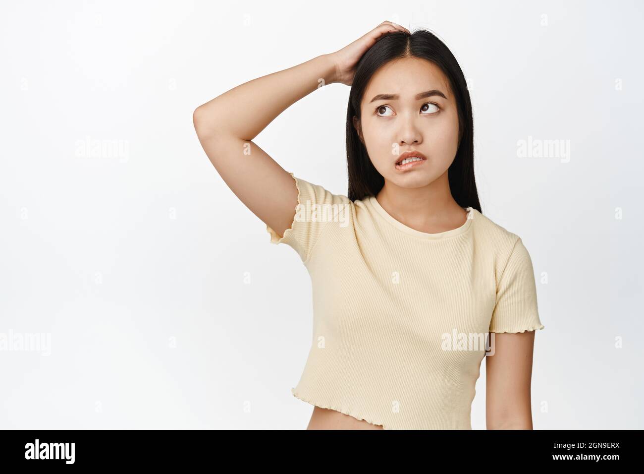 Confused asian woman scratch head, looking aside with puzzled face ...